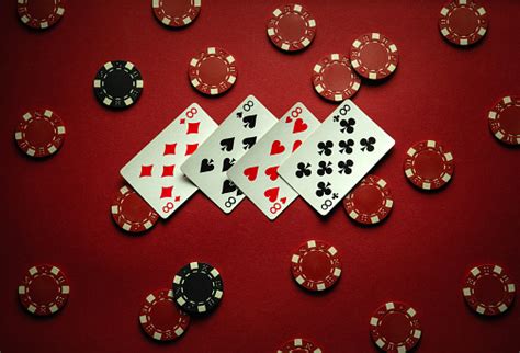 클럽의 빨간 테이블에서 그들은 칩을 핥고 카드 놀이를 하며 4가지 종류 또는 쿼드의 승리 조합을 가지고 있습니다 카지노에서 성공적인 게임 또는 행운의 개념 0명에 대한 스톡