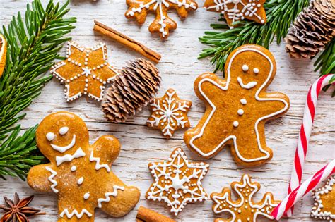 크리스마스 진저 브레드와 과자는 나무 책상에 배치됩니다 별과 눈 조각모양의 쿠키와 달콤한 음식 겨울 테마 소박한 스타일 측면에