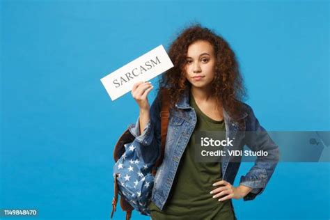 데님 옷 배낭 홀드 기호 파란색 벽 배경 스튜디오 초상화에 고립에서 젊은 아프리카계 미국인 소녀 십 대 학생 고등학교 대학 대학 개념에서 교육 복사 공간을 모의 합니다