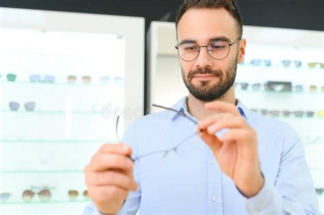 Man Chooses Glasses For Vision Correction In An Ophthalmology Salon Glasses For Vision