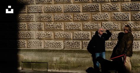 검은 재킷과 파란색 데님 청바지를 입은 남자가 콘크리트 벤치에 앉아 있다 사진 Unsplash의 무료 목욕 이미지