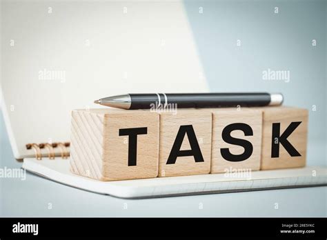 Task Office Notebook Pen And Wooden Blocks With The Word TASK Written