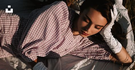 낮 동안 갈색 잔디밭에 누워 있는 빨간색과 흰색 긴팔 셔츠를 입은 여자 사진 Unsplash의 무료 사람의 이미지