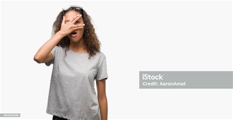 아름 다운 젊은 히스패닉 여자 얼굴과 손으로 눈을 덮고 충격 엿보기 안경을 쓰고 당황된 하는 표정으로 손가락을 통해 찾고 T 셔츠에 대한 스톡 사진 및 기타 이미지 Istock