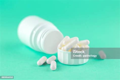 알 약과 캡슐 아쿠아 마린 배경 복사 공간에 모자에 밖으로 유출 흰색 알 약 병을 닫습니다 전경 부드러운 Bokeh에 초점 약국 약국 개념 0명에 대한 스톡 사진 및 기타
