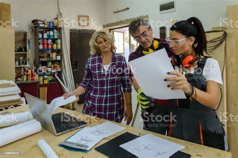 목수 그룹은 워크샵에서 종이 계획을 보고 새로운 프로젝트에 노력하고 있습니다 3 명에 대한 스톡 사진 및 기타 이미지 3 명 30 34세 55 59세 Istock