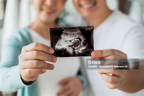 아시아 임산부 부부는 집에서 행복한 쇼 초음파 이미지를 느끼고 초음파 이미지에 초점을 맞추고 임신에 대한 스톡 사진 및 기타 이미지 Istock