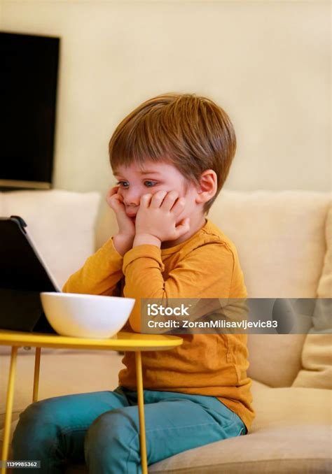 가정에서 침대에 태블릿 Pc를 사용 하는 아이 소파에 귀여운 소년은 만화를 보고 게임을 재생 하 고 노트북에서 학습 교육 재미