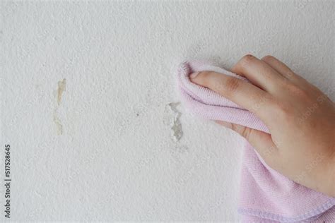 Woman Cleaning And Remove Sticky Rough Glue And Tape Remain On The Old Concrete Wall Stock