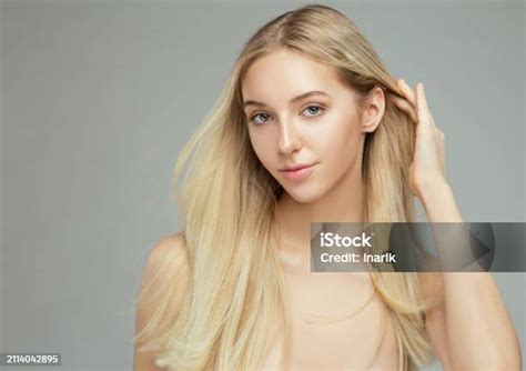 귀를 보여주는 긴 실크 머리를 가진 아름 다운 금발 소녀 회색 배경 위에 자연스러운 메이크업과 금발 헤어스타일을 가진 뷰티 모델 금발 머리에 대한 스톡 사진 및 기타 이미지