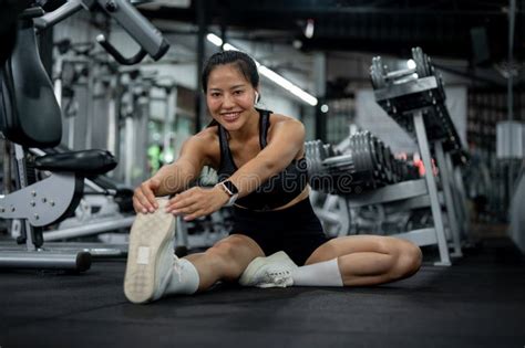 An Attractive Sporty Asian Woman In Athletic Wear Is Sitting On The