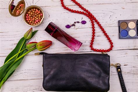 흰색 나무 배경에 여성 액세서리 및 메이크업 화장품 클러치 백 향수 아이 섀도우 루즈 볼 목걸이 귀걸이 및 튤립 아름다움과 패션 구성 상단 보기 플랫 레이 0명에 대한 스톡