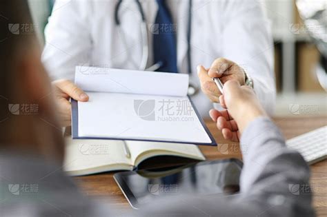 男医生手递给病人银笔和便签