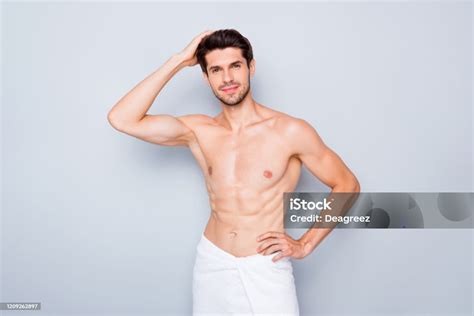 잘 생긴 근육 남자 방문 미용사 절차의 초상화는 부드러운 신선한 머리를 즐길 수 안티 비등 샴푸 스탠드 에 목욕 흰색 수건 위에 고립 된 회색 색상 배경 갈색 머리에 대한