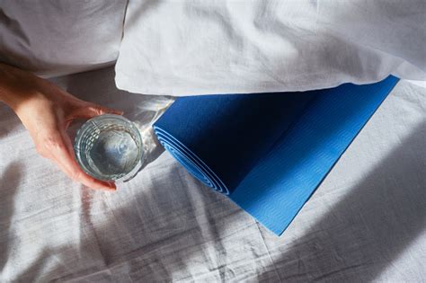 요가 매트와 소녀의 손에 물 한 잔이 밝은 배경에 클로즈업되어 있다 건강 및 스포츠 개념 가정 생활에 대한 스톡 사진 및 기타 이미지 가정 생활 가정의 방 건강한