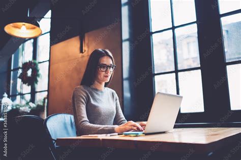 Foto De Babe Charming Female IT Programmer Loading Upgraded Software Into Laptop Computer To