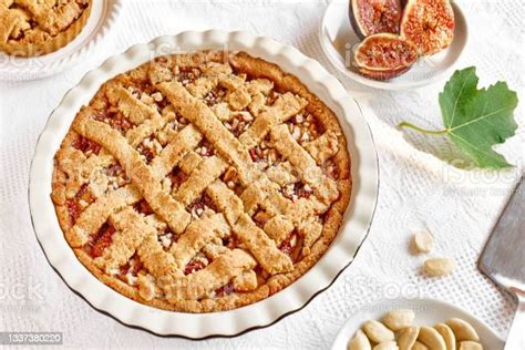 쿠키 크러스트 베이스를 곁들인 수제 무화과 타르트 흰색 식탁보가있는 테이블에 무화과와 아몬드가있는 쇼트 브레드 파이 가을 베이킹