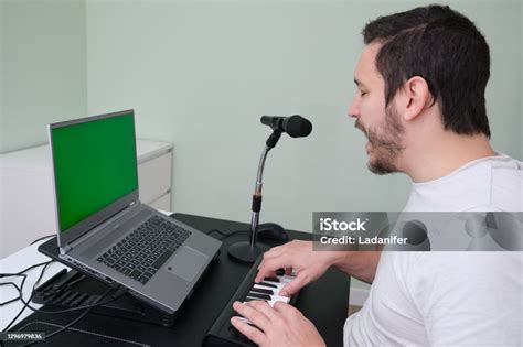 남자 블로거 Youtuber 인플루언서 전자 피아노를 연주하고 집에서 노래하는 비디오를 녹화 음악가 가수 피아노 플레이어 노트북의 녹색 화면입니다 가수에 대한 스톡 사진 및
