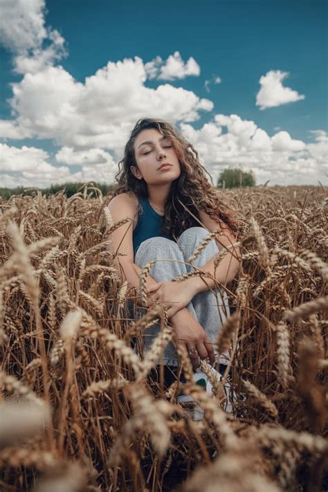 Beautiful Teenage Girl With Long Curly Hair Posing In A Field Stock