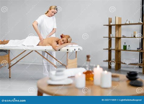 Masajista Frotando Aceite De Masaje En La Espalda Imagen De Archivo