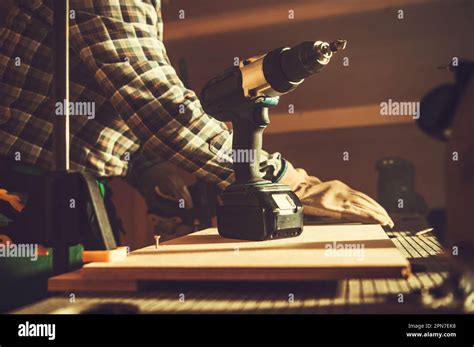 Closeup Of Cordless Electric Screwdriver On The Background Of Woodworking Workshop Construction