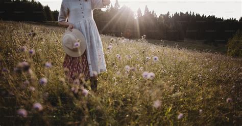 산속의 햇살이 내리쬐는 초원에 있는 야생화와 허브 소박한 드레스와 모자를 쓴 세련된 소녀의 흐릿한 이미지 해질녘에 시골에서 휴식을 취하는 보호 여자 소박한 삶 대기