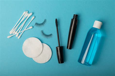 메이크업 지울 수 있는 미셀라 워터 마스카라 화장솜 피지와 메이크업의 피부를 클렌징합니다 파란색 배경에 구성입니다 아름다움 개념입니다 공간 텍스트를 복사합니다 플랫 레이 0