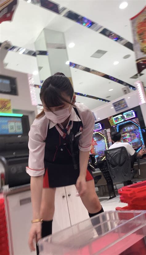 A Woman Wearing A Face Mask Standing In Front Of A Display Case At A Store
