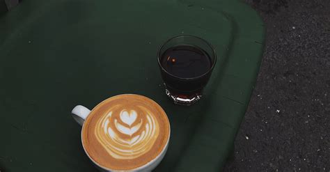 집 밖의 거품 깨지다 녹색 의자 단순한 대조 도시 생활 도시 설정 디자인 따뜻한 음료 라떼 라떼 아트 라이프스타일 미니멀리스트 바리스타 사교적인