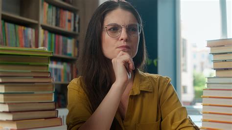 수심에 잠긴 여성 사려 깊은 여성 소녀 고등학생 교사 교사 생각 숙고 교육 수업 공부 학습 시험 준비 도서관 도서관 책 대학