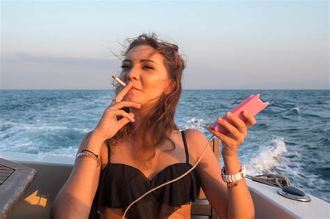 젊은 우크라이나어 여자 모델 흡연 요트 Heybeliada 이스탄불 터키의 해안 근처에서 전화를 갈색 머리에 대한 스톡 사진 및 기타 이미지 Istock