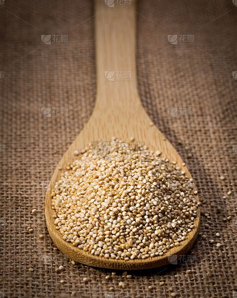 木勺和亚麻背景上的藜麦种子
