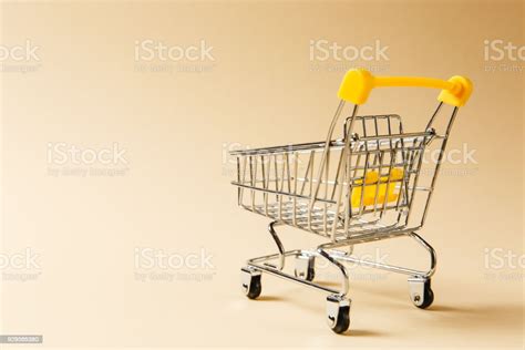 검은 바퀴와 핸들 베이지색 배경에 고립에 노란색 플라스틱 요소 쇼핑 슈퍼마켓 식료품 푸시 카트 닫습니다 쇼핑의 개념입니다 광고에 대 한 공간을 복사 Publicity