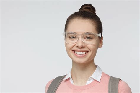 매력적인 젊은 여자의 회색 배경 롤빵 큰 투명 안경으로 묶어 머리에 고립 된 웃 고 웃 고 공개적으로 실내 샷 가장자리에 대한 스톡 사진 및 기타 이미지 Istock