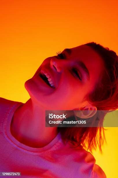 여러 가지 빛 네온 빛에 오렌지 스튜디오 배경에 고립 된 백인 여성의 초상화 네온에 대한 스톡 사진 및 기타 이미지 네온 사람들 가수 Istock