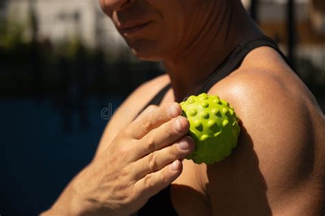Athletes Man Is Massaging His Shoulder By Massage Ball Techniques For Tense After Active Workout