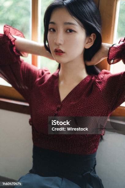 우아한 빨간 셔츠를 입고 방의 창문에 머리를 고정하는 한국 여성 기대기에 대한 스톡 사진 및 기타 이미지 기대기 벽 빨강 Istock