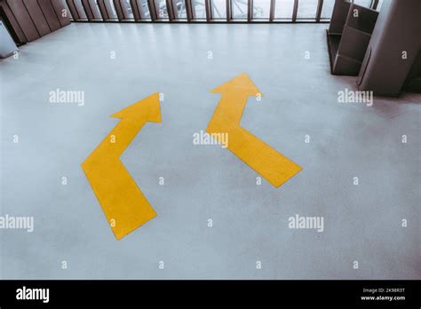 Two Indoor Yellow Stickers In The Shapes Of Broken Arrows As A Way