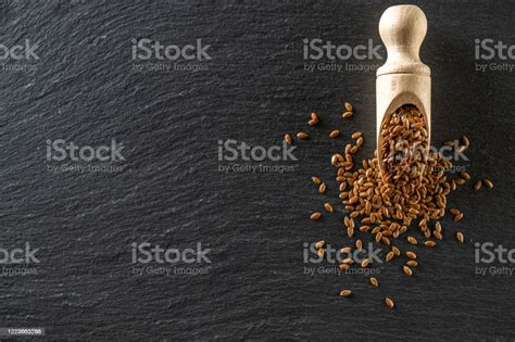 어두운 배경에 고립 된 아마씨 갈색 아마 아마 씨 돌에 나무 스쿱에 유기 오일 린넨 씨앗 건강한 간식 원시 건조 비건 식품 스낵 컨셉 0명에 대한 스톡 사진 및 기타 이미지