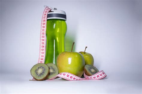 녹색 스포츠 병 사과와 키위 위에 빨간색 측정 테이프 다이어트와 건강한 삶 체중 감량 스포츠 컨셉 맨 위 보기입니다 공간을 복사합니다 격리 흰색 배경 가냘픈에 대한 스톡