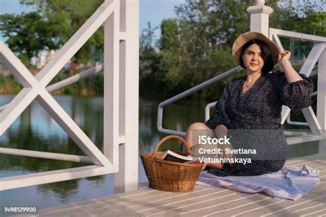 엄마와 딸은 호숫가에서 소풍을 가며 전화로 만화를 보고 있다 25 29세에 대한 스톡 사진 및 기타 이미지 25 29세 가을 강 Istock