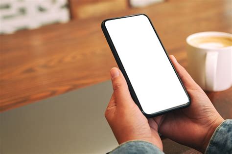 테이블에 노트북과 커피 컵 빈 데스크톱 화면과 검은 휴대 전화를 들고 손의 모형 이미지 휴대전화에 대한 스톡 사진 및 기타 이미지 휴대전화 가득 찬 공란 Istock