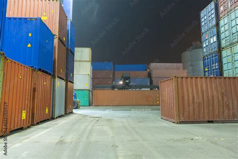 Loading And Unloading Containers In Port On Night Reach Stacker Is Lifting Container While