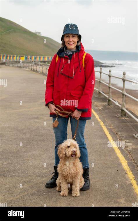 Smiling Caucasian Mature Female Dressed In A Red Waterproof Coat And