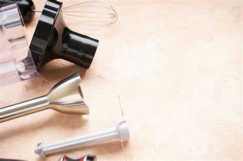 베이지 색 배경에 스테인레스 스틸 바디와 액세서리가있는 전기 핸드 블렌더 텍스트 배치 플레이 는 누워 강철에 대한 스톡 사진 및