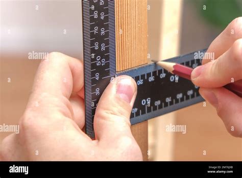 Carpenter Using Carpenter Square To Mark The Line Of Wood Cut For