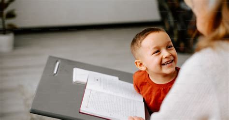 책을 들고 있는 어린 소년 옆에 앉아 있는 여자 사진 Unsplash의 숙제 이미지