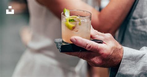 노란 액체로 마시는 유리를 들고 하얀 드레스를 입은 여자 사진 Unsplash의 무료 독일 이미지