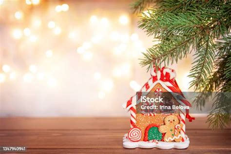 보케 조명의 배경에 전나무 가지가있는 나무 테이블에 크리스마스 진저 브레드 하우스 공간을 복사합니다 인사말 카드 새해 복 많은 새해와 메리 크리스마스 진저브레드 하우스에