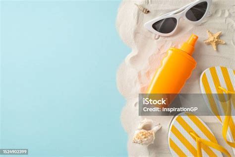 자외선 차단제 마케팅 개념입니다 안경 슬리퍼 조개껍데기 파스텔 블루와 모래 배경에 불가사리와 짝을 이루는 브랜드 없는 자외선 차단 로션의 상단 보기 라벨 또는 광고를 위한